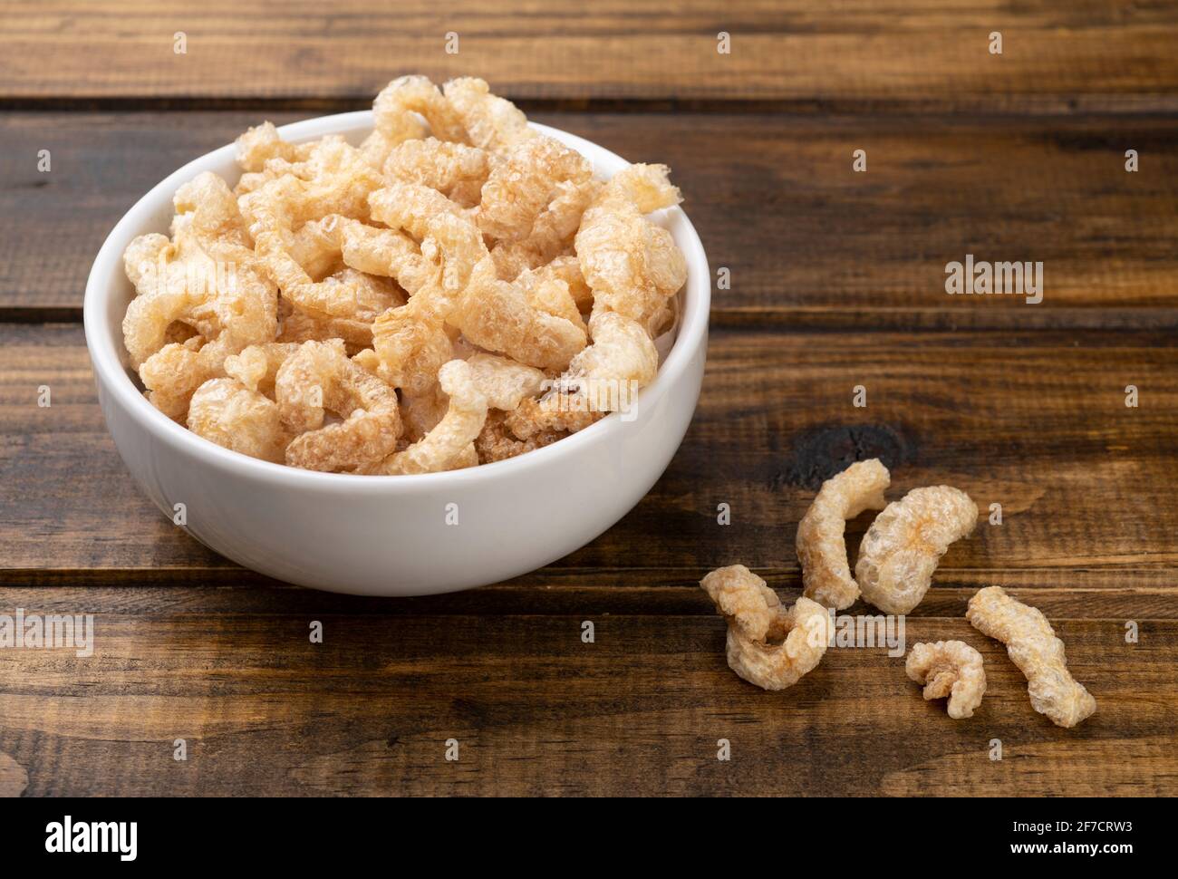 Fried pork cracklings on a white bowl over wooden table Stock Photo - Alamy