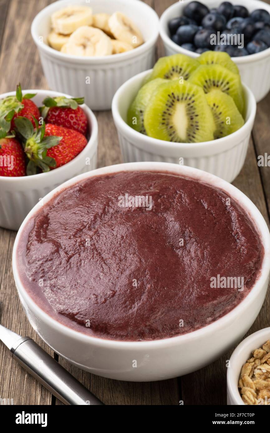 Brazilian typical acai bowl with fruits and muesli over wooden ...