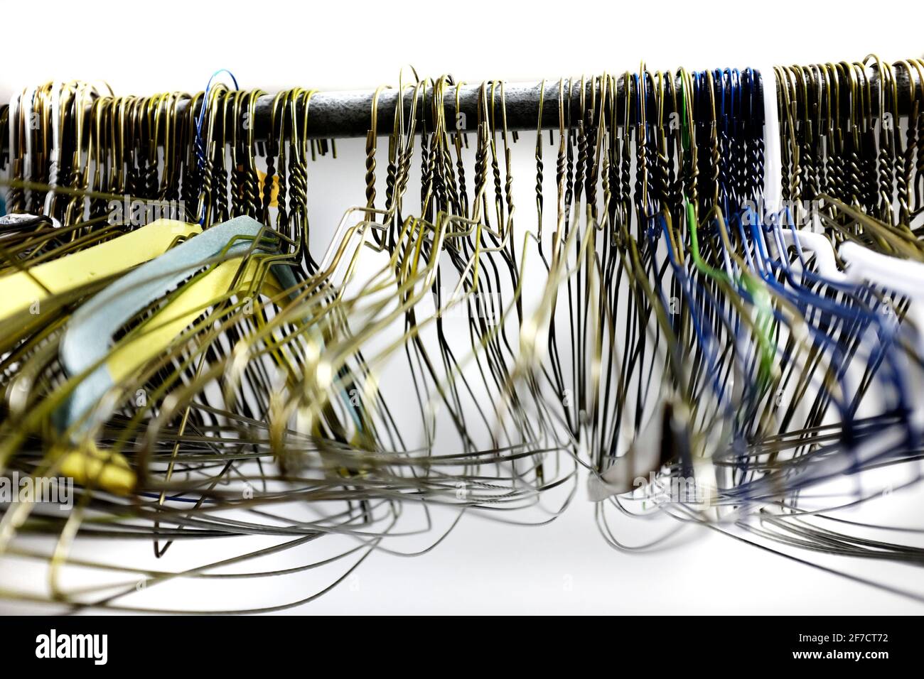 Wire hangers on pole rod in closet for hanging clothes Stock Photo - Alamy