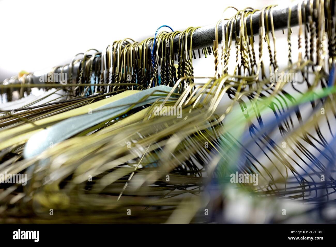 Wire hangers on pole rod in closet for hanging clothes Stock Photo - Alamy