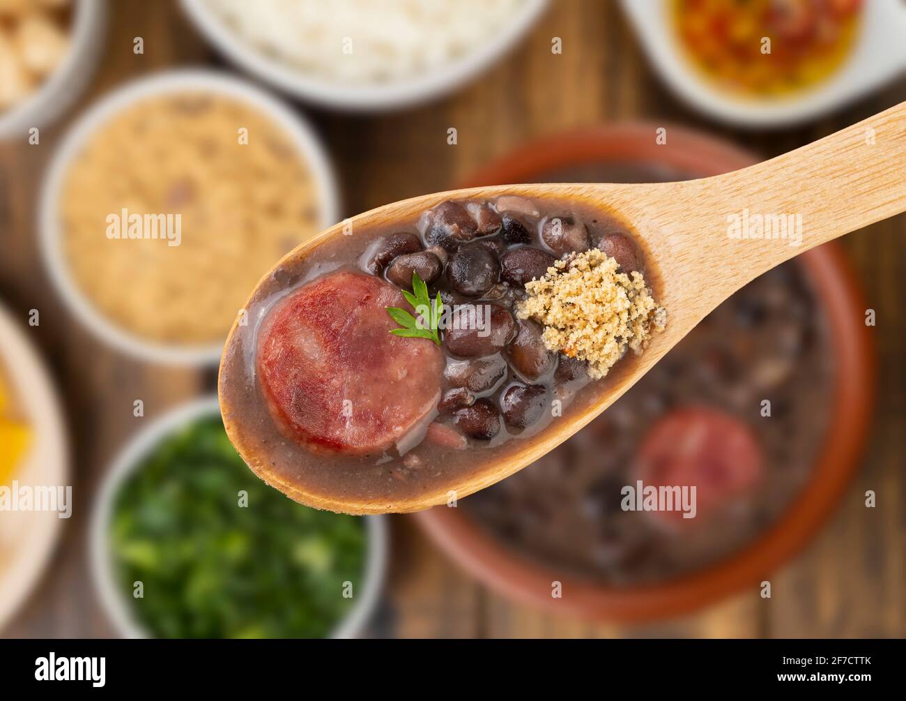 Traditional brazilian feijoada in a spoon over unfocused background ...