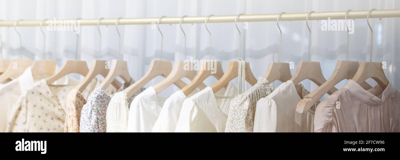 Row of different female clothes hanging on rack in hipster fashion show ...