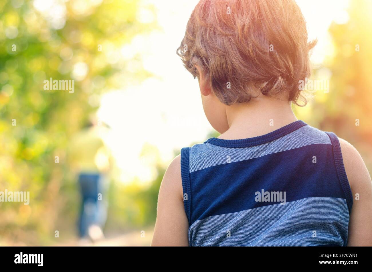 little boy follows his mother along the road Stock Photo - Alamy