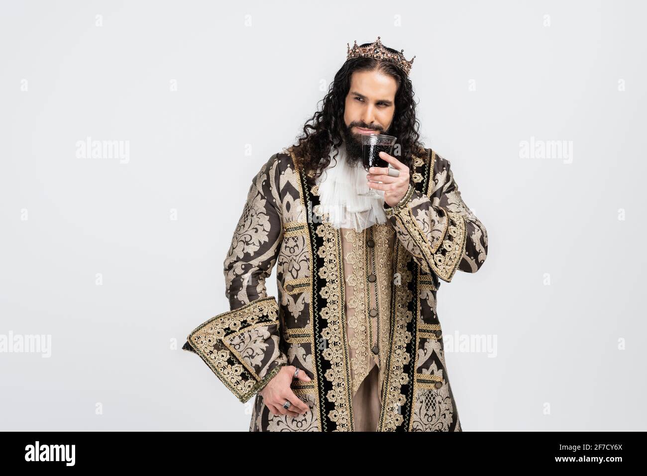 hispanic king in medieval clothing and crown holding glass with red ...