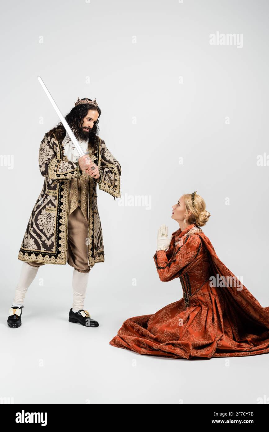 full length of cruel hispanic king in medieval clothing holding sword ...