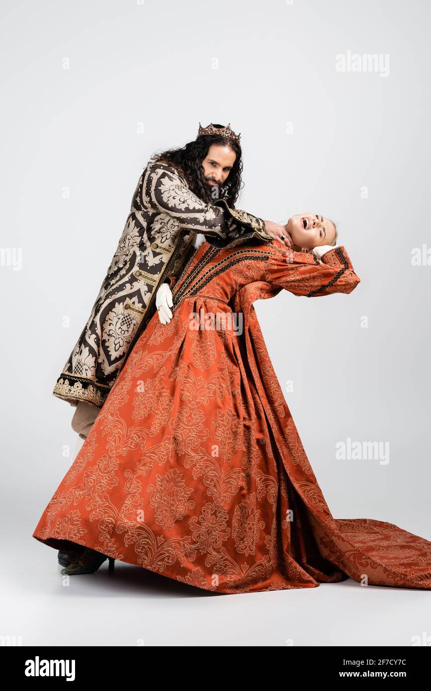 full length of cruel hispanic king in medieval clothing choking shocked ...