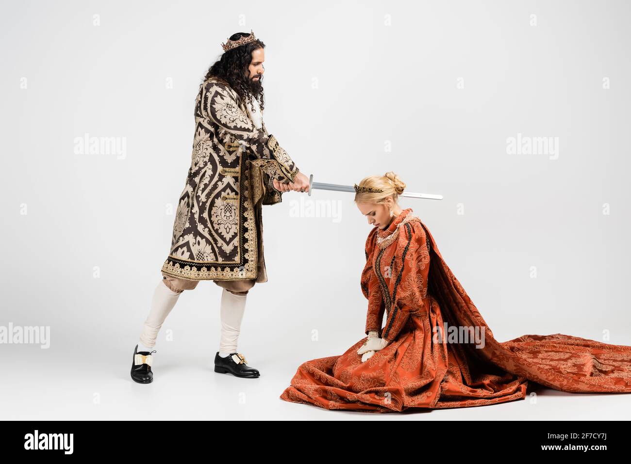 full length of cruel hispanic king in medieval clothing holding sword ...