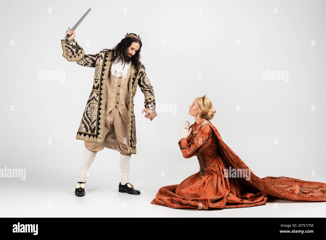 full length of hispanic king in medieval clothing holding sword near ...