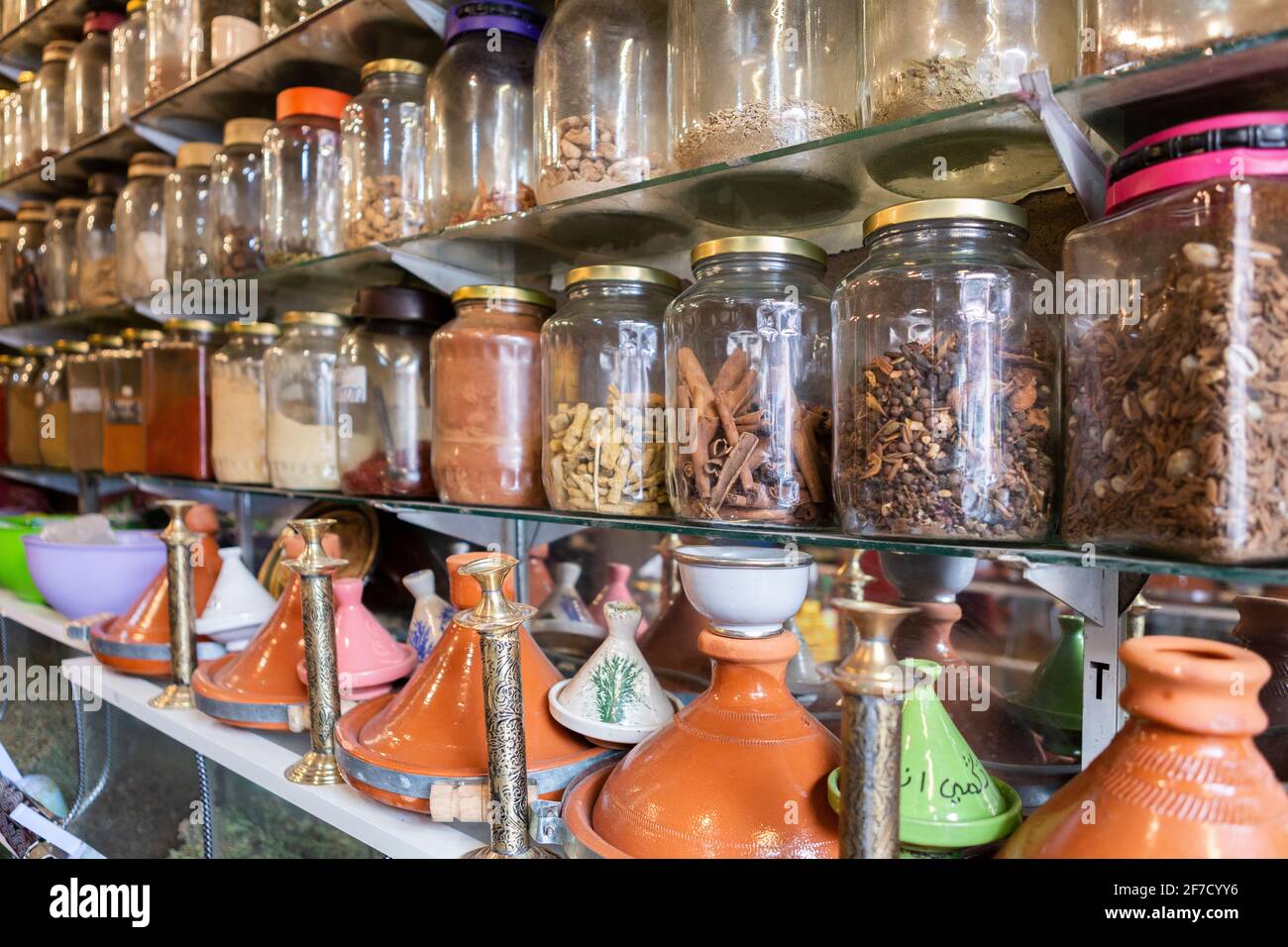 Jars with spices and tagines on a shelf in a shop in the medina of ...