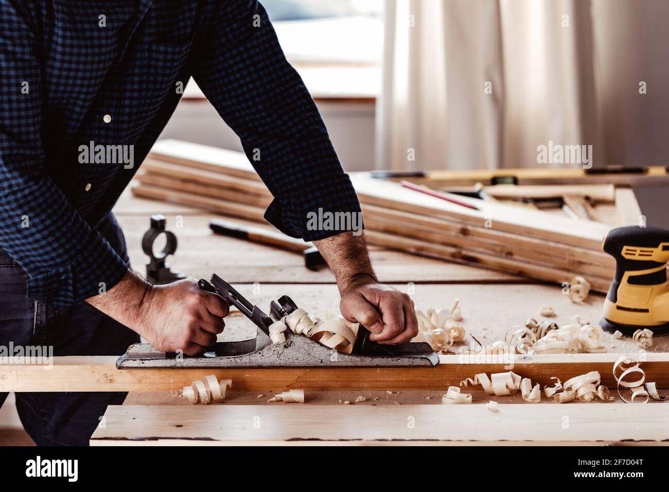 Carpenter's hands planing a plank of wood with a hand plane Stock Photo ...