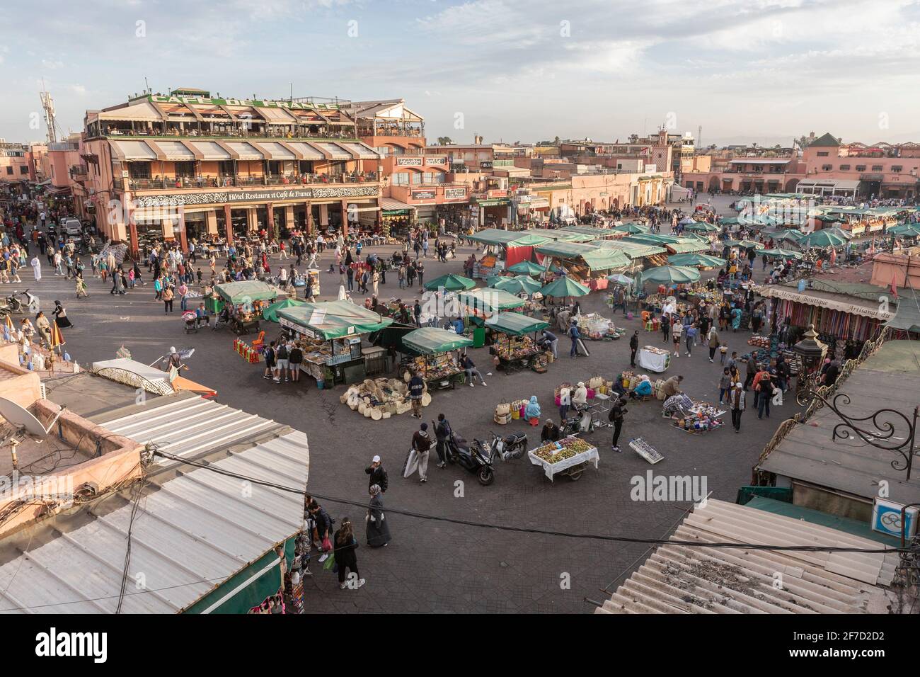 Hustle and bustle around the Market stands with their green roofs at ...