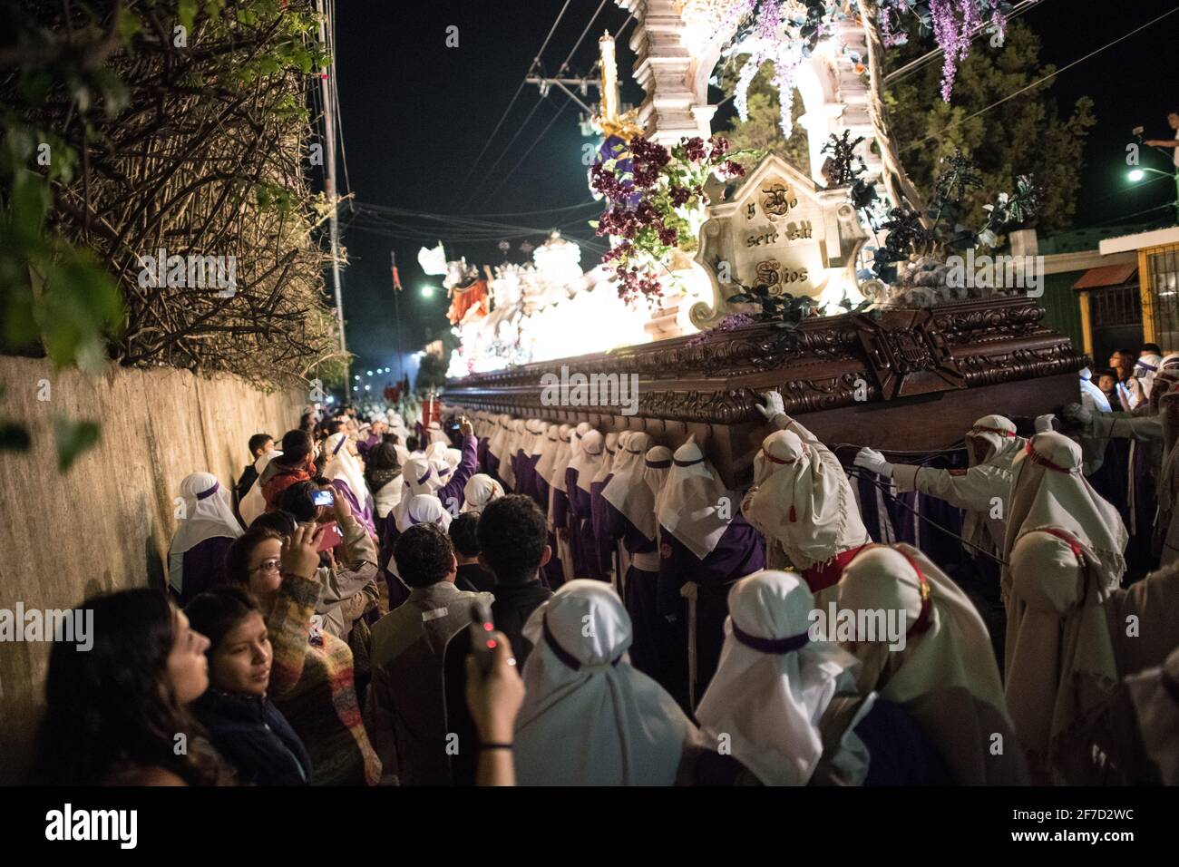 Cucuruchos in purple robes process solemnly through the streets of ...
