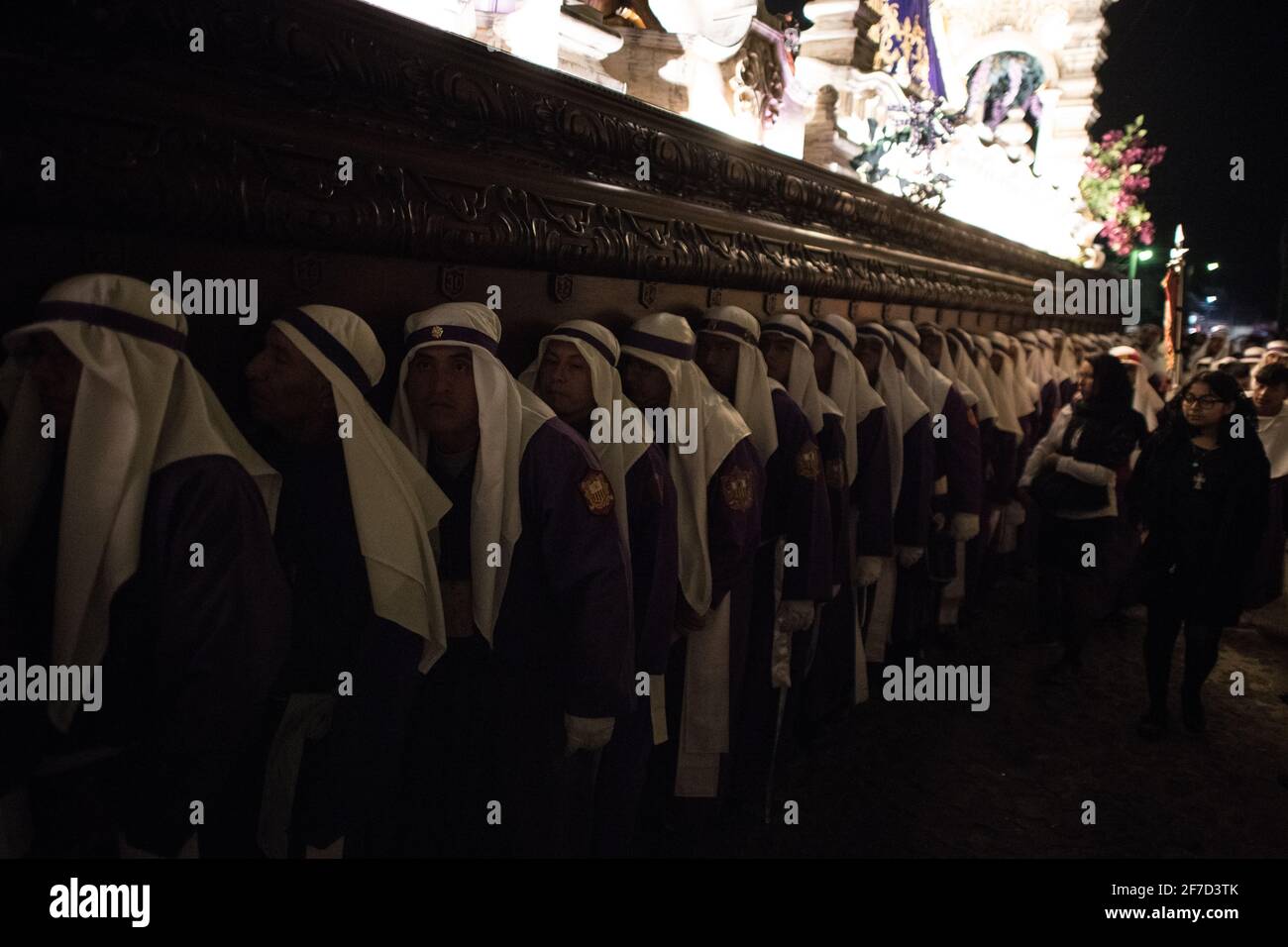 Cucuruchos in purple robes process solemnly through the streets of ...