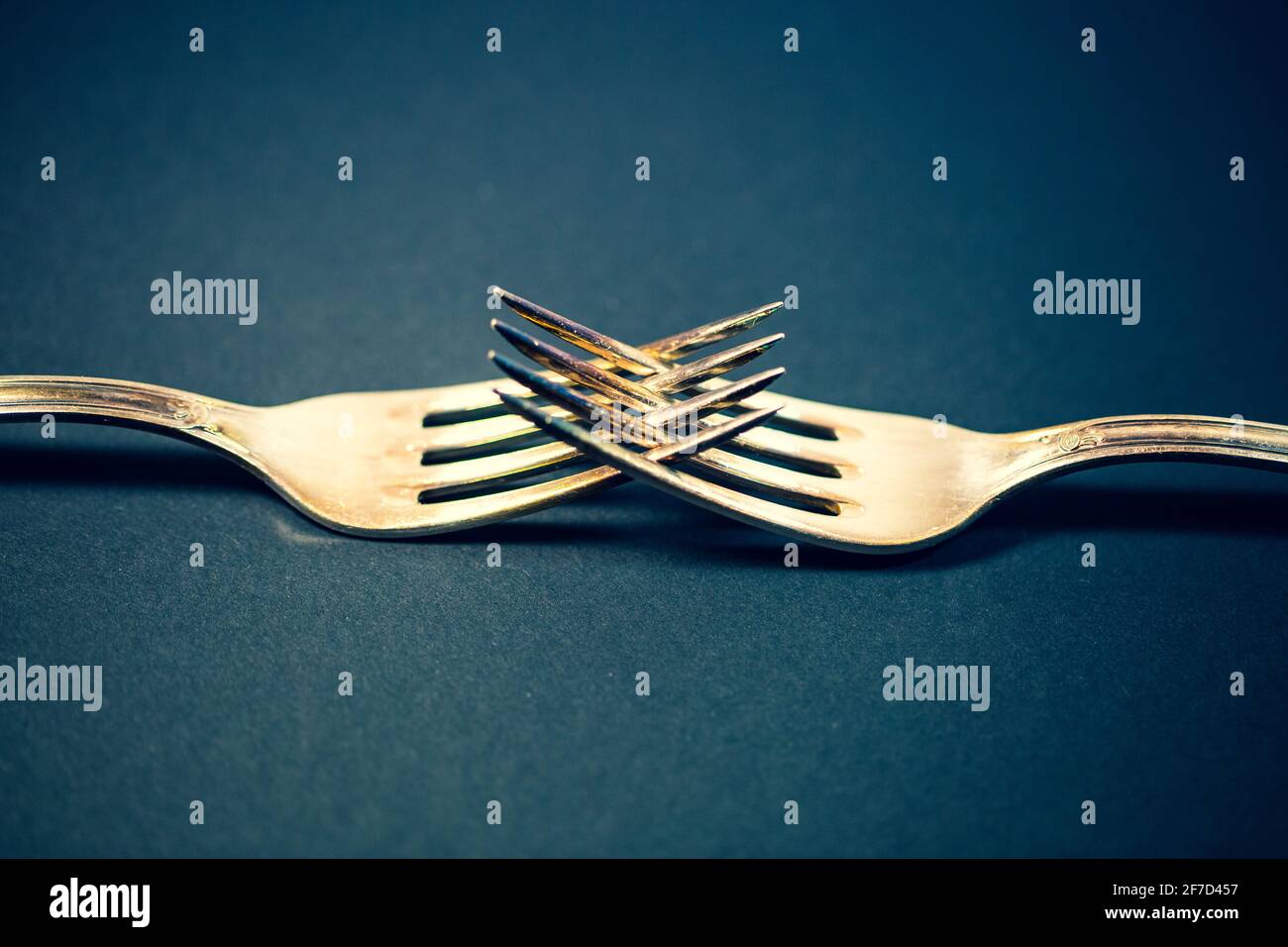 two forks on a gray background Stock Photo - Alamy