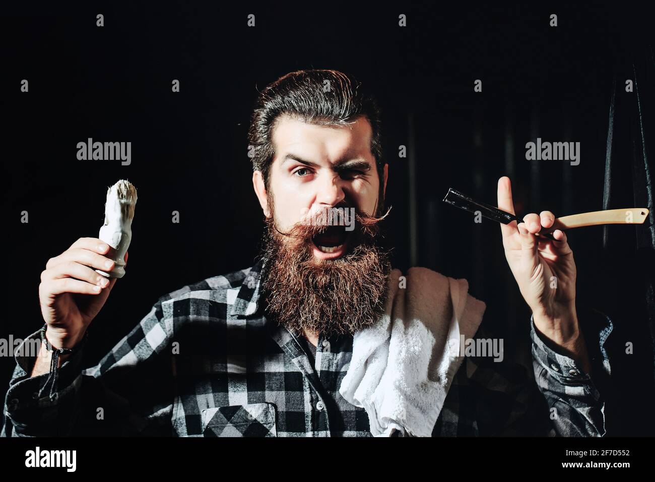 Excired barber. Bearded man in barbershop. Barber scissors and straight ...