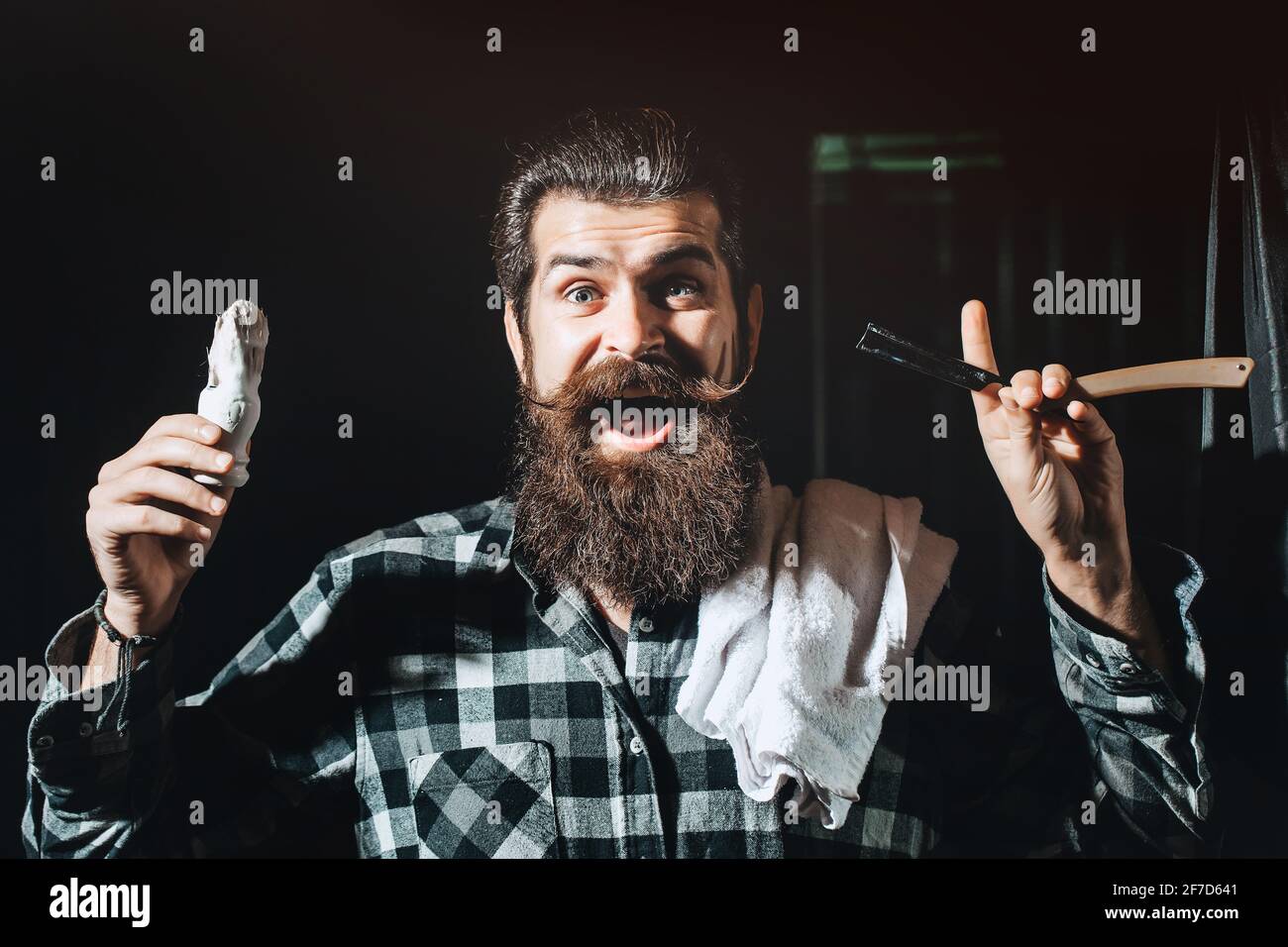 Funny bearded Barber with scissors and straight razor in barber shop ...