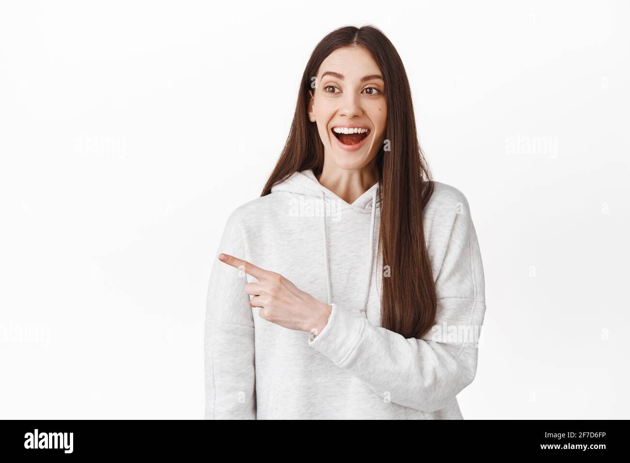 Cheerful teen girl laughing, smiling and looking joyful, pointing at ...