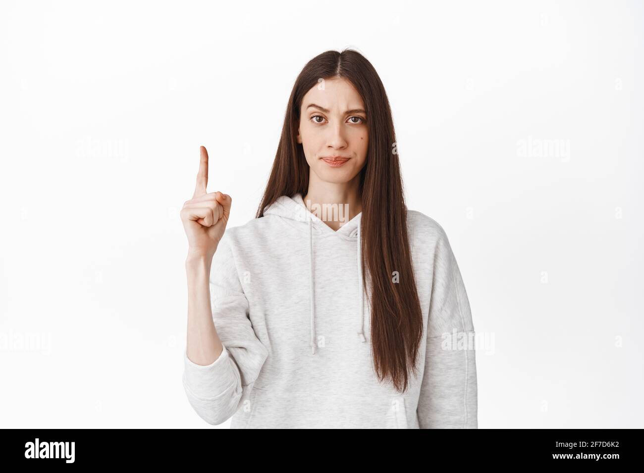 Disappointed frowning girl pointing finger up, looking with displeased ...