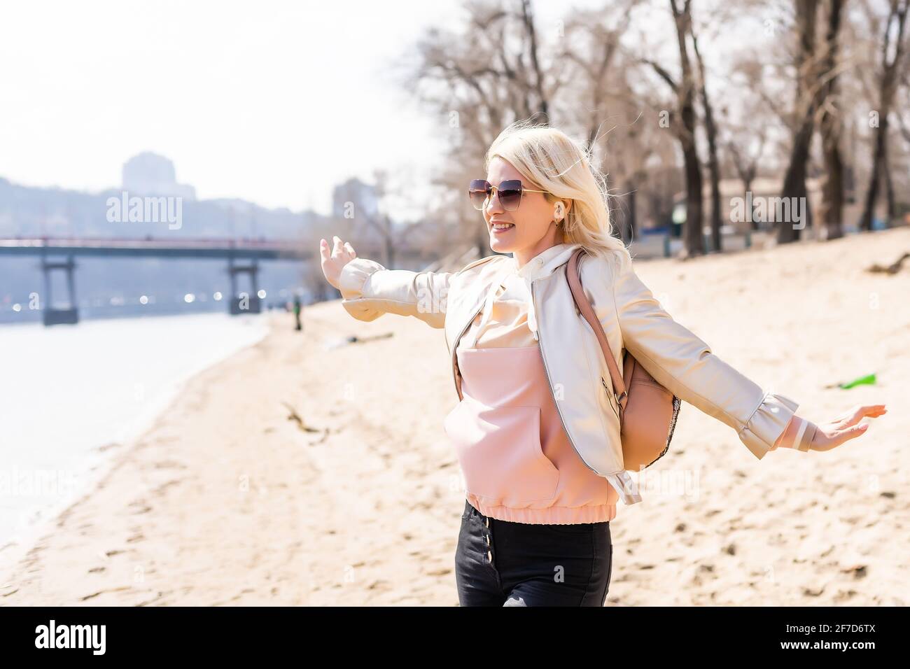 young woman raising arms up towards blue sky and river Stock Photo - Alamy