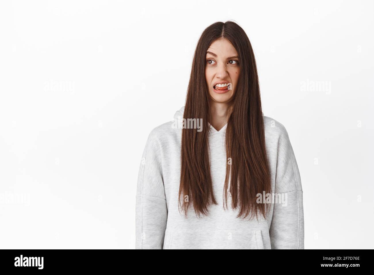 Disgusting. Young funny girl with long hair, look disgusted aside ...