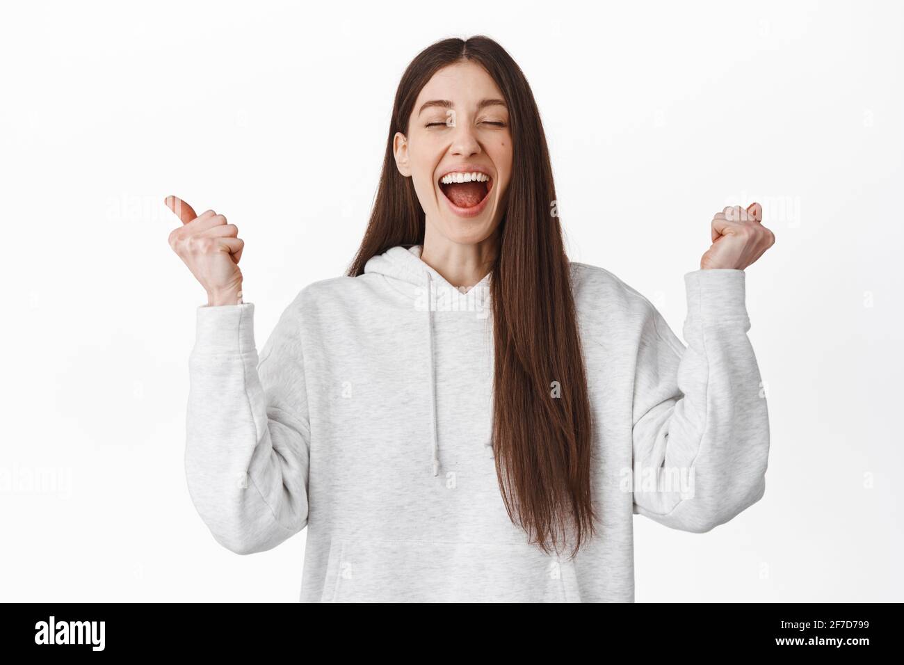 Relieved and happy girl scream from excitement and joy, shaking hands ...