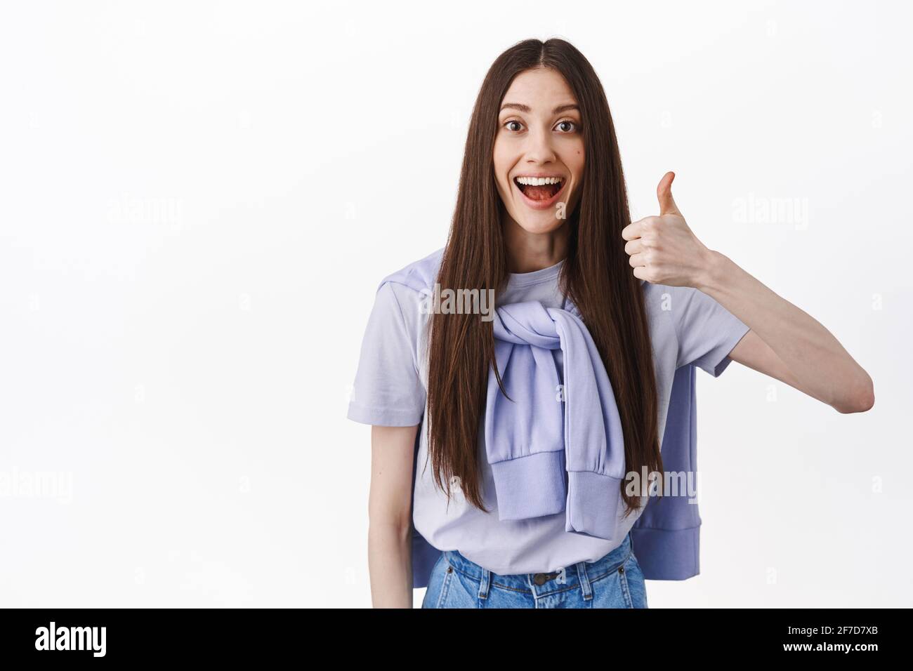 Well done, nice. Smiling amused woman with long hair, shows thumb up in ...