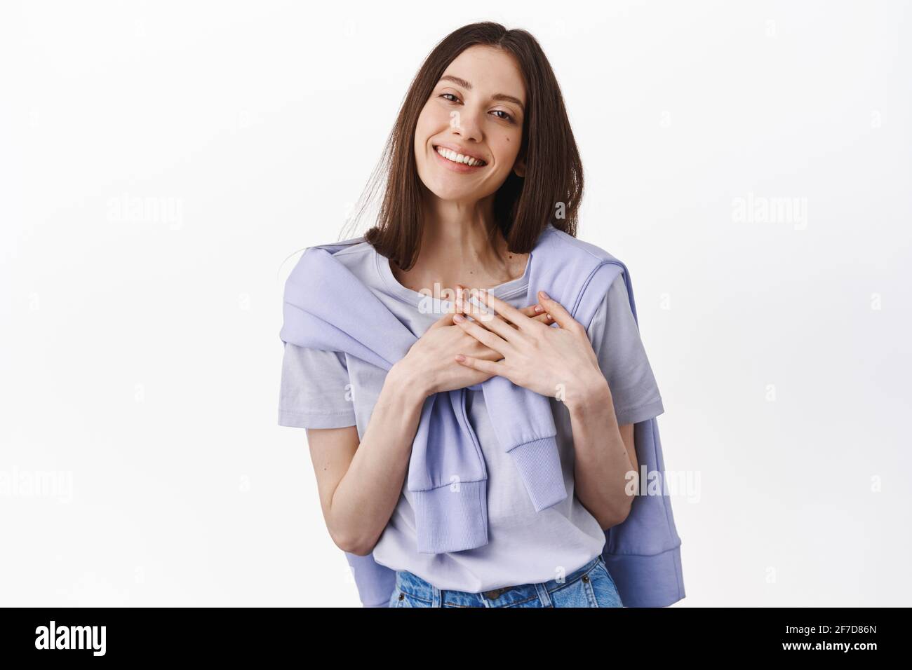 With all my heart. Touched and thankful cute girl smiling, holding ...