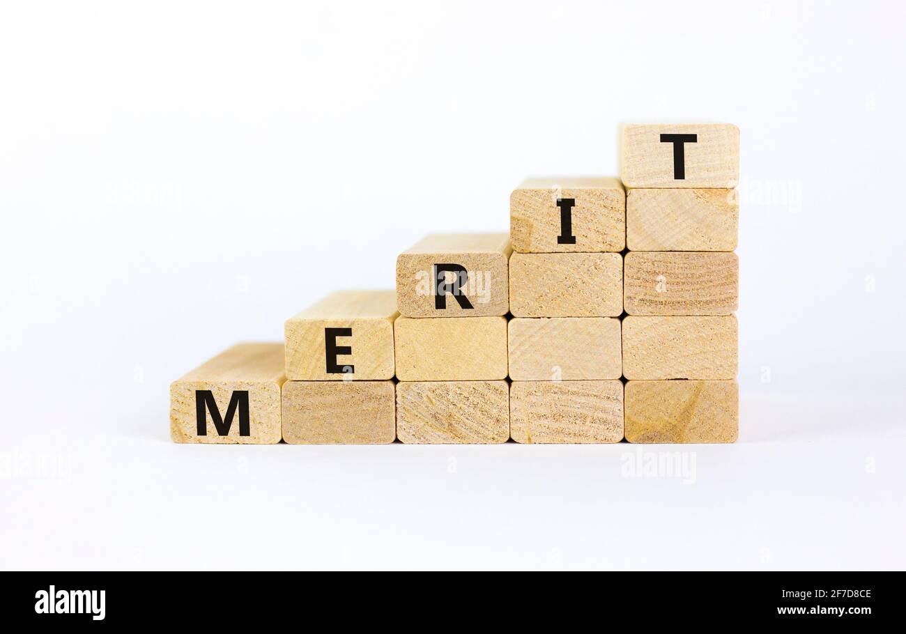 Merit symbol. Wooden blocks with the word 'merit'. Beautiful white ...