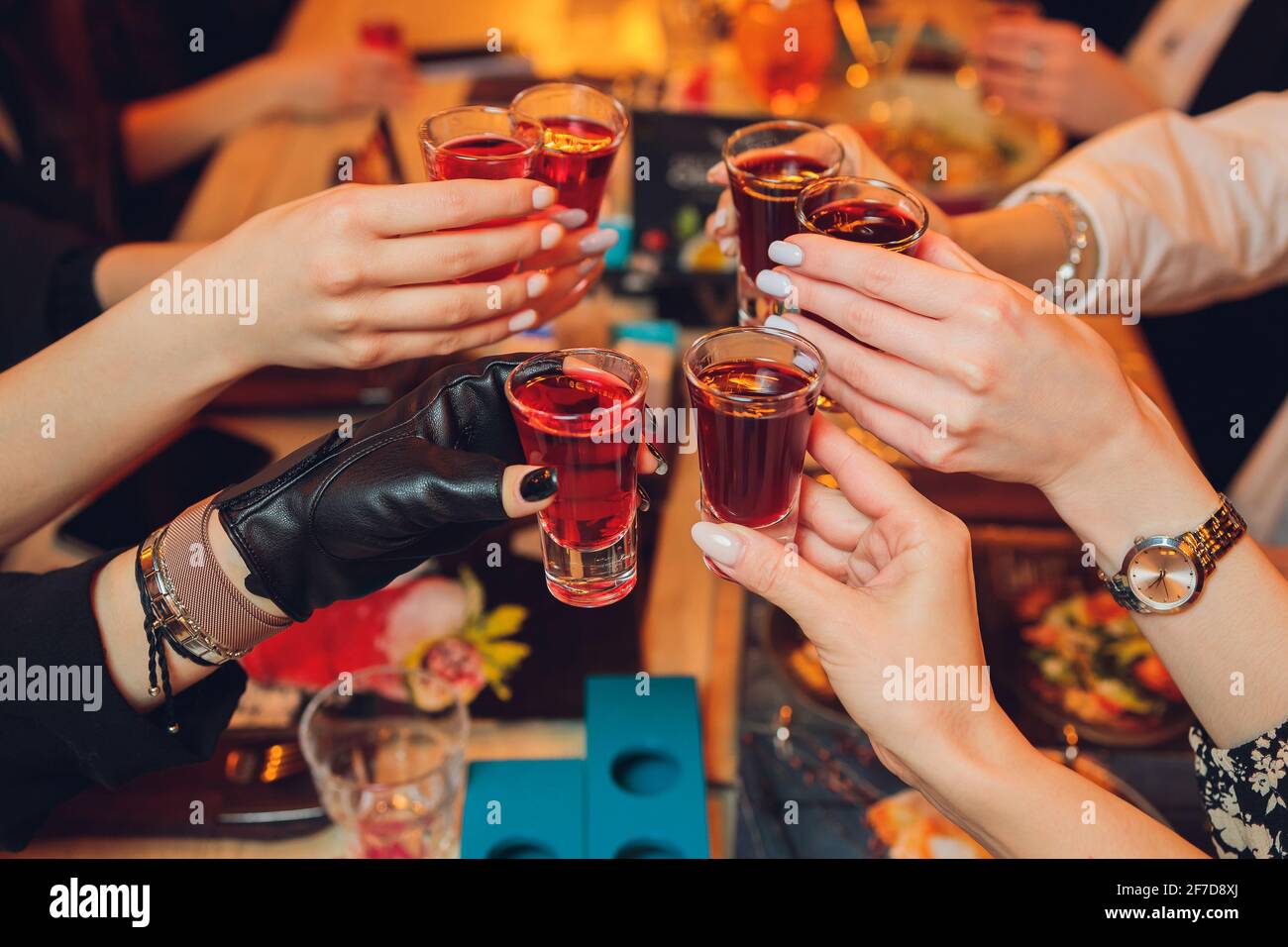 Clinking glasses with alcohol and toasting, party Stock Photo - Alamy