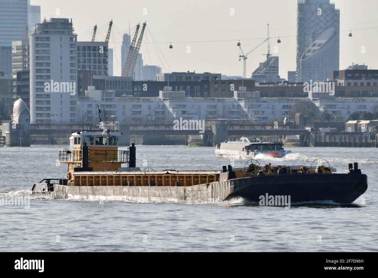 Pusher tug with a loaded hopper barge heading down the River Thames in ...