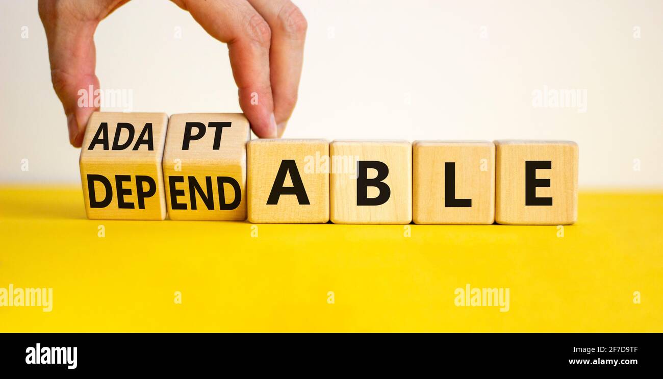 Adaptable or dependable symbol. Businessman turns wooden cubes and changes the word dependable ...