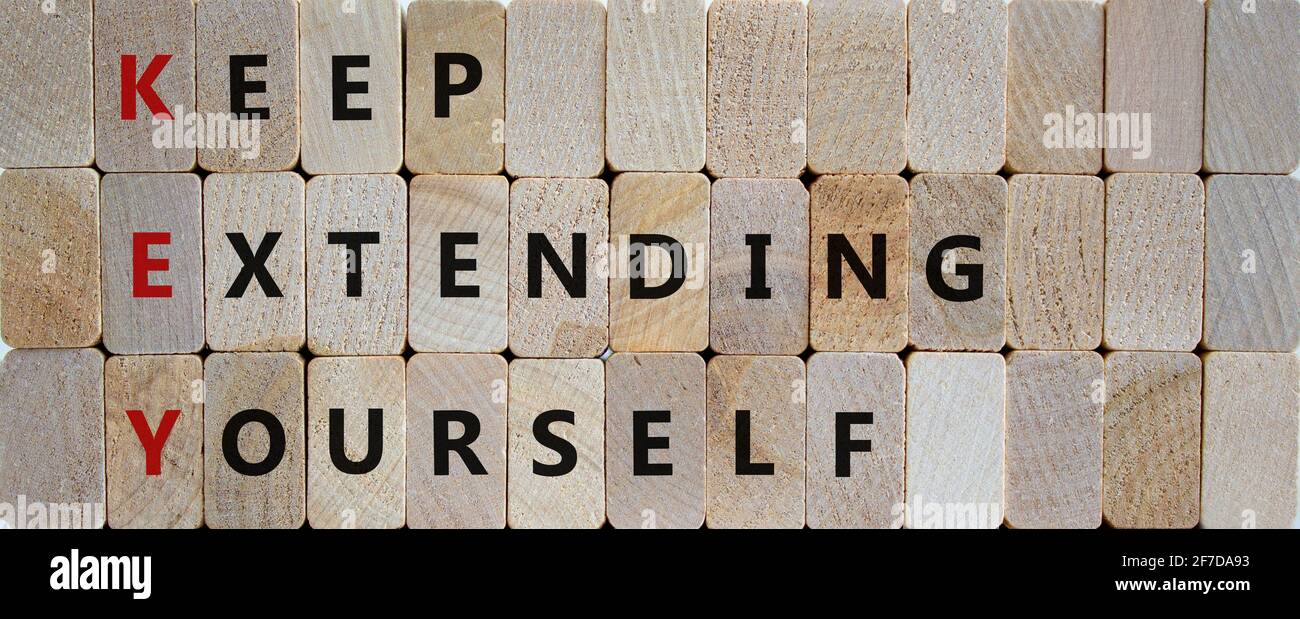 KEY, keep extending yourself symbol. Wooden blocks with words 'KEY ...