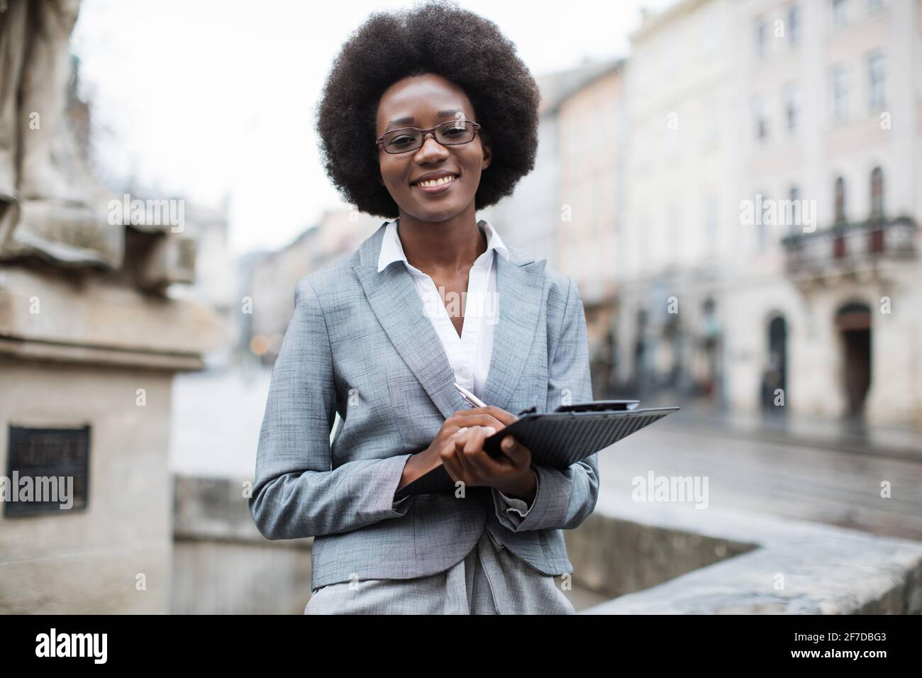 Front view of smiling african business woman in stylish formal clothes ...