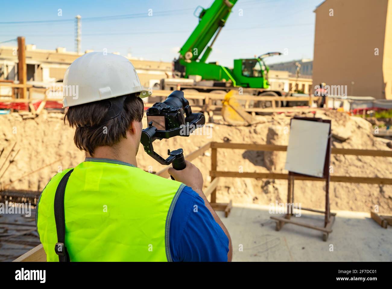 a videographer, dressed in safety gear, with a camera and stabilizer in ...