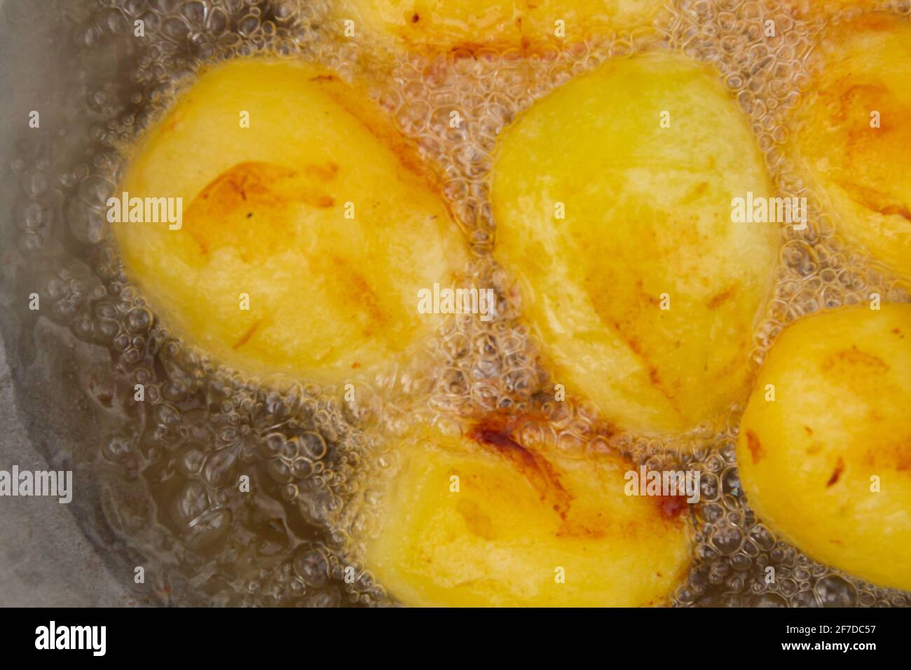 Golden potatoes are fried in boiling oil in a cauldron Stock Photo - Alamy