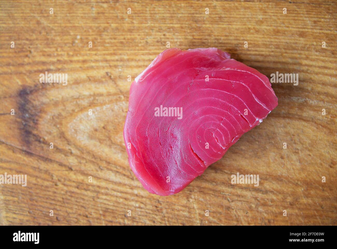 Raw tuna steak on a wooden board, top view. Delicious and healthy food ...