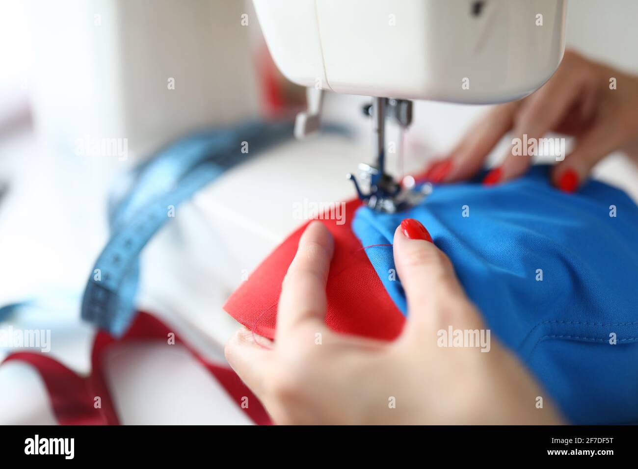 Close-up of professional tailor female working on electrical white ...