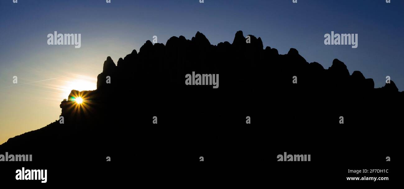 Roca Foradada of Montserrat with the sun rising through the rock hole ...