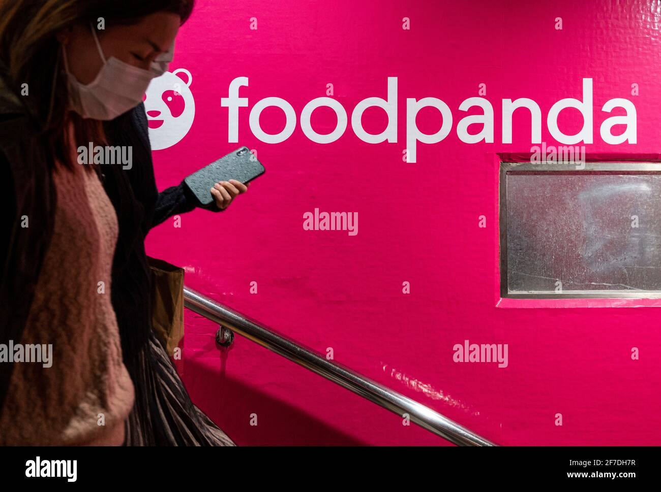 A pedestrian walks past a street commercial advertisement of the ...