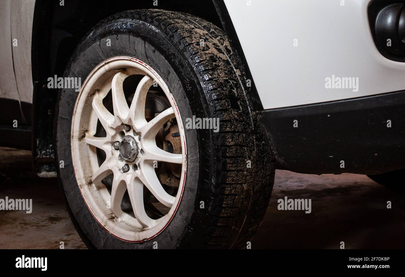 Muddy snow tires on a white SUV, white rim and slight vignette, Toronto ...