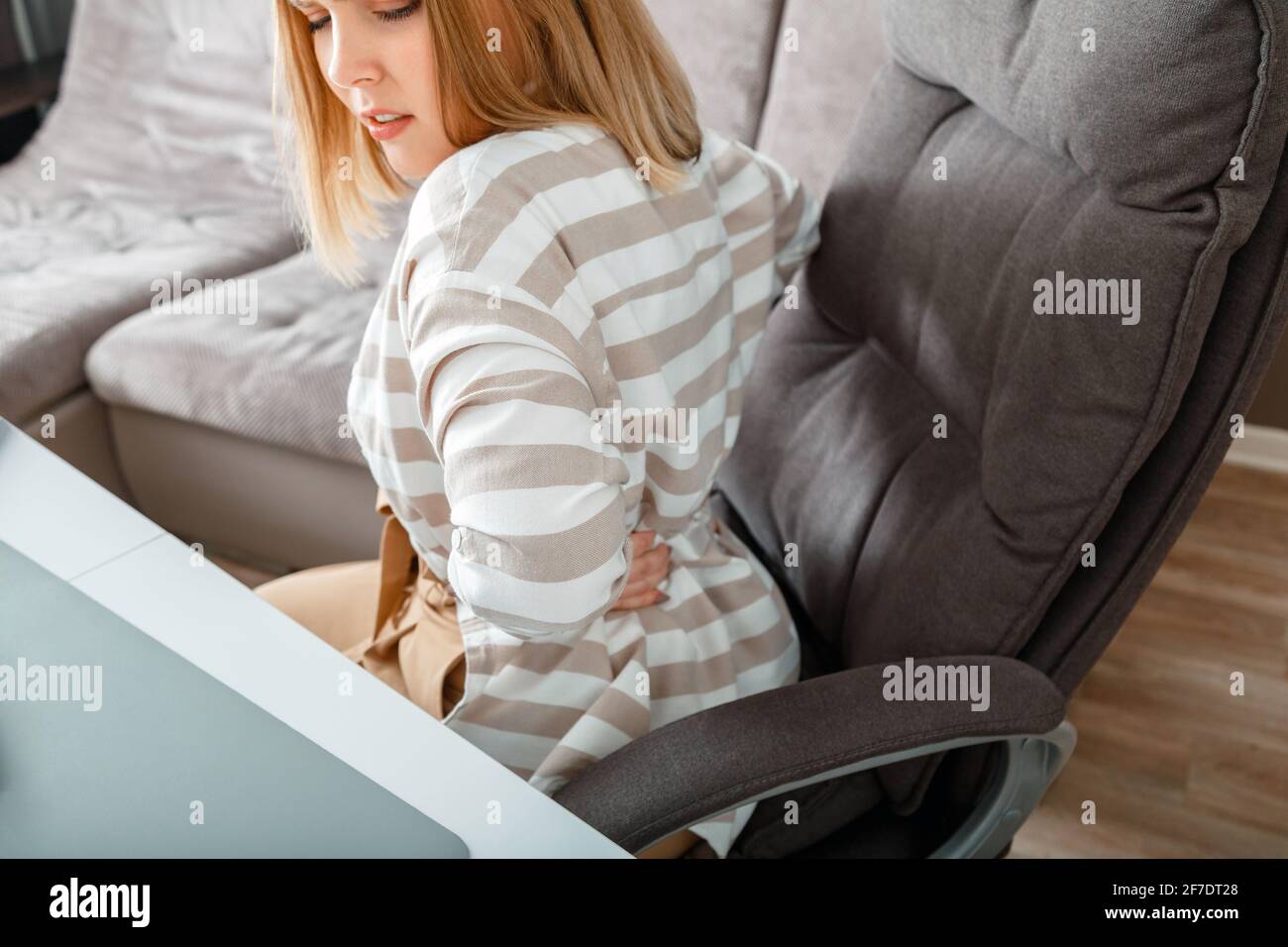 Young woman have Back pain sitting on office chair. Acute neck spinal ...