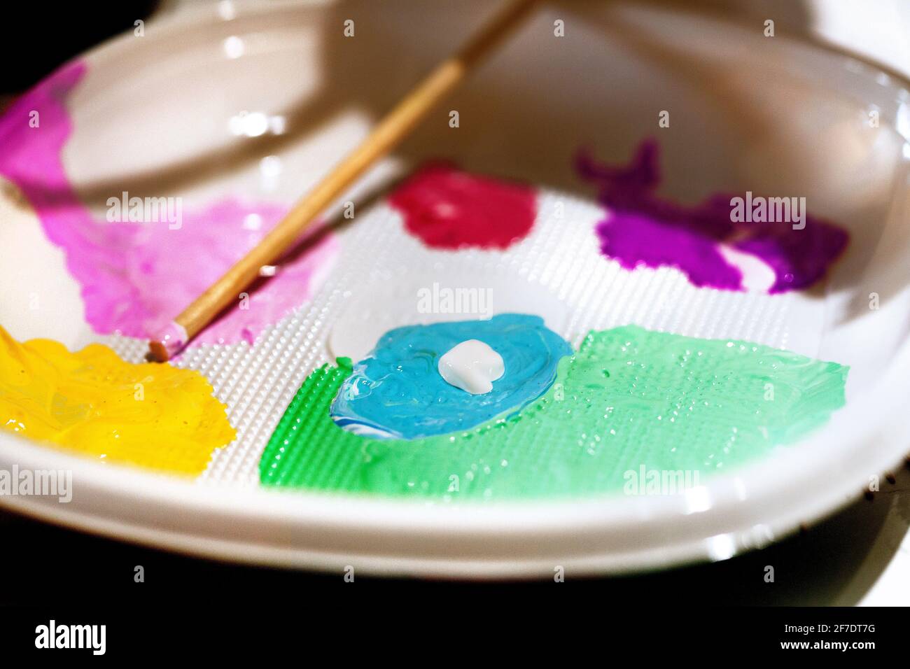 Plastic plate being used as a paint palette Stock Photo - Alamy
