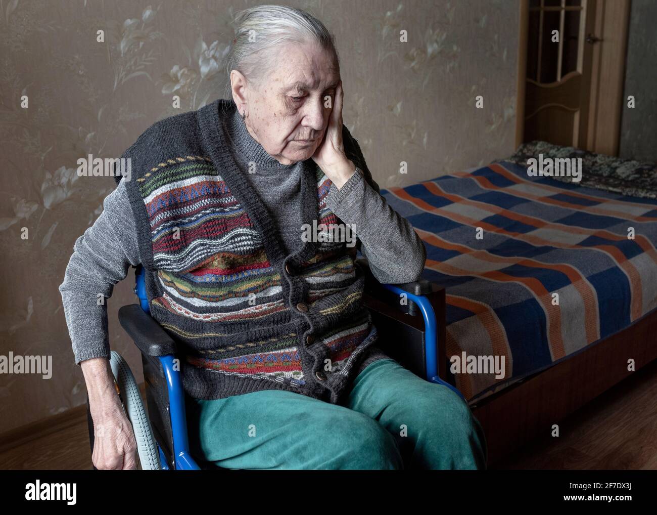 Portrait of sad lonely old woman sitting in a wheelchair. Old age ...