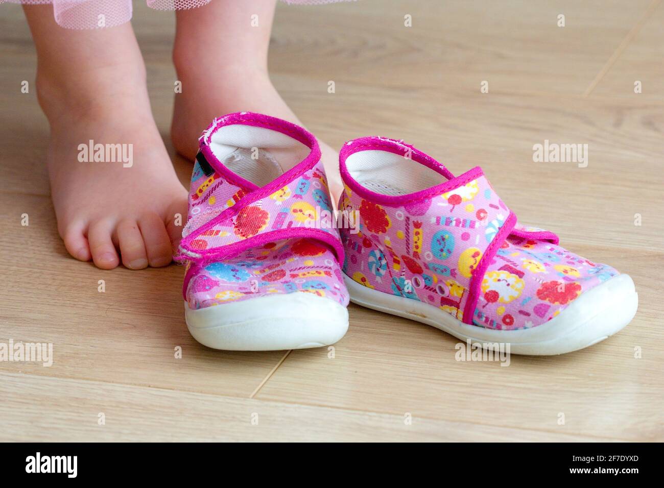 Kids pink slippers with kids foot on background Stock Photo - Alamy