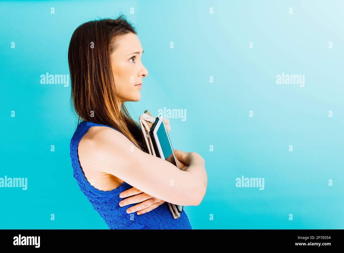 Beautiful young woman in profile holding tablet with space for looking ...