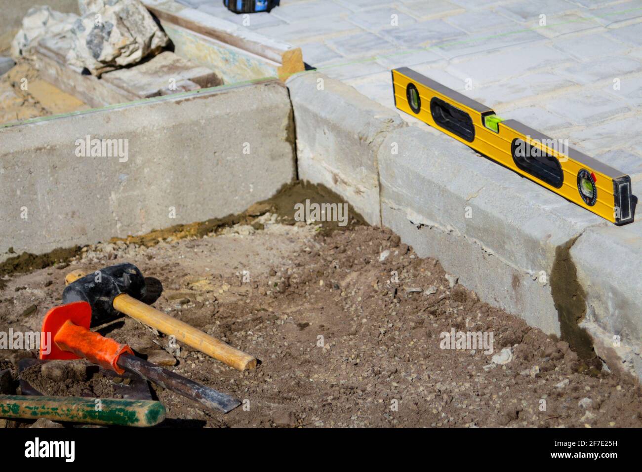 Defocus Paving Backyard Patio. Yellow spirit level, hammer, mallet ...