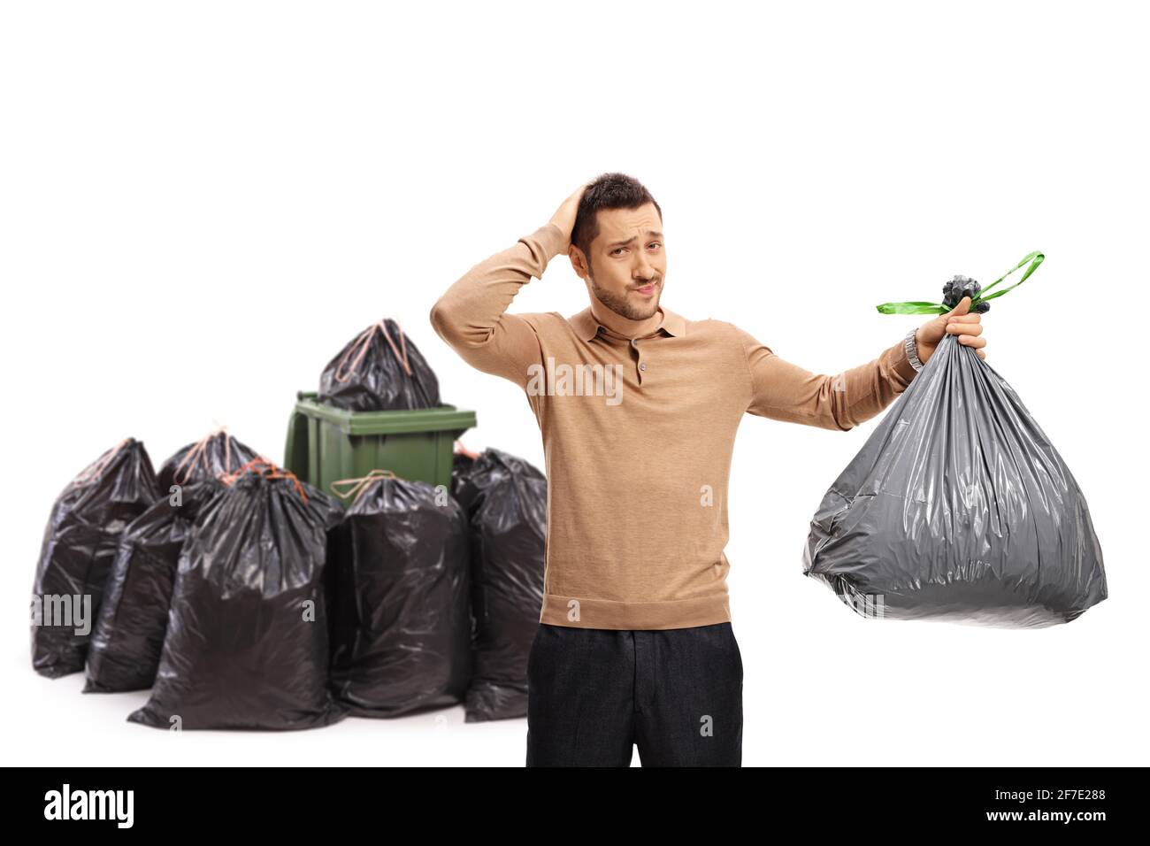 Man with a garbage bag holding his head in disbelief in front of a bin ...
