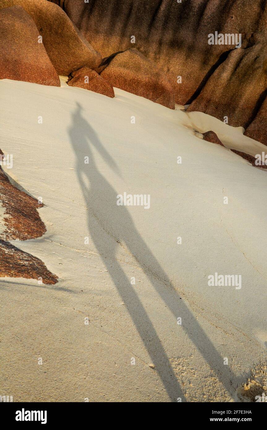 Shadow of a woman on a sandy tropical beach with granite rocks Stock ...