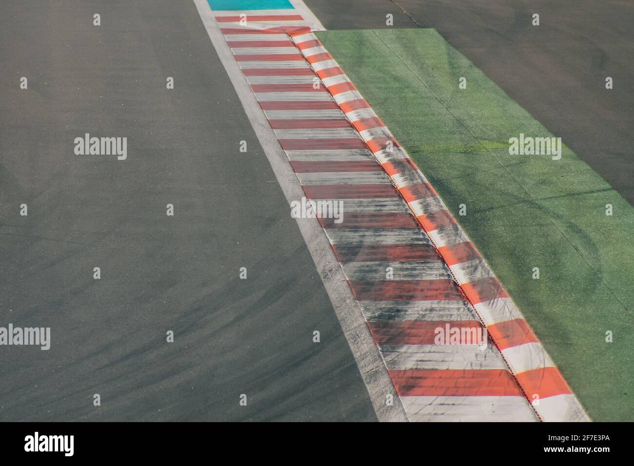 Edge of a racetrack curve on the exit, with visible skid marks or ...