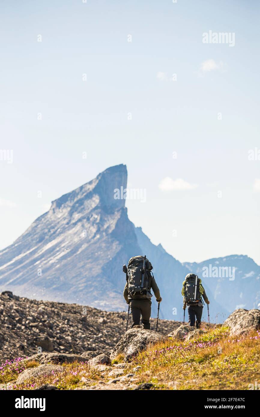 Two backpackers hike below Mt. Thor, Canada Stock Photo - Alamy
